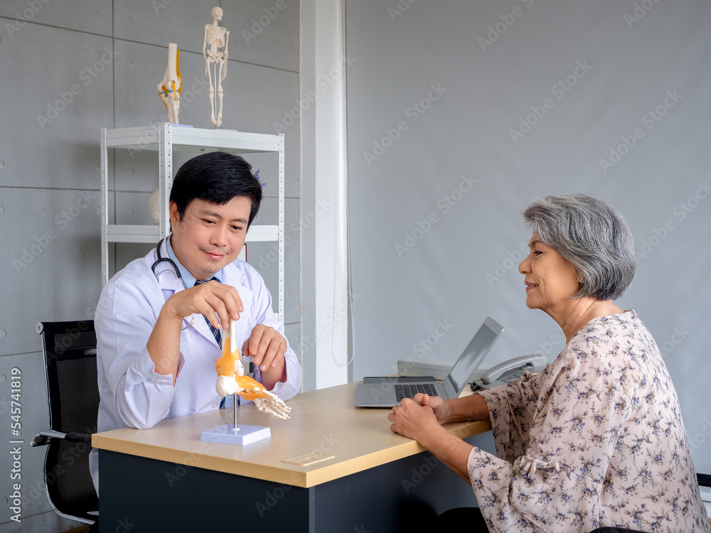 Smiling professional Asian man orthopedic doctor pointing to foot ...