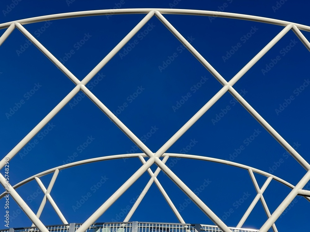 White metal pipes forming pattern structure against blue sky, modern ...