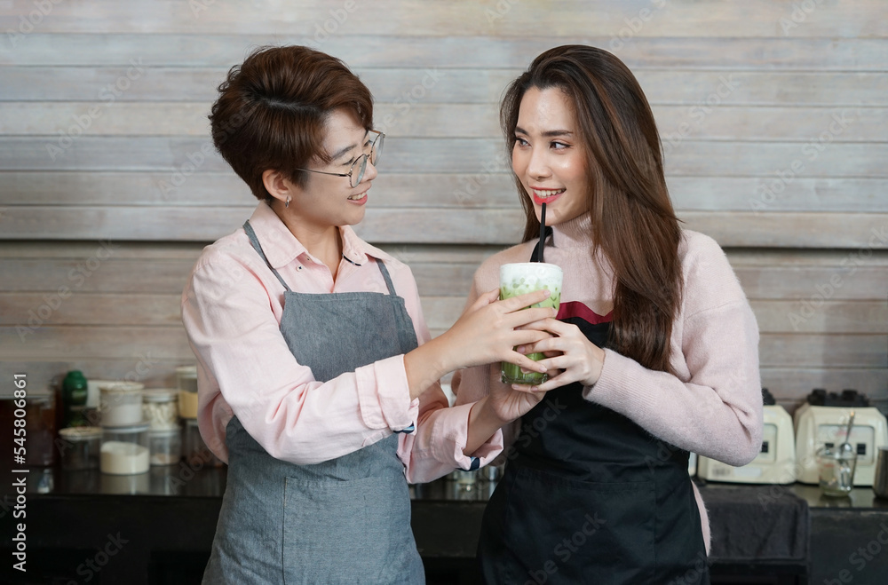 romantic woman lesbian couple having iced green tea drink in their ...