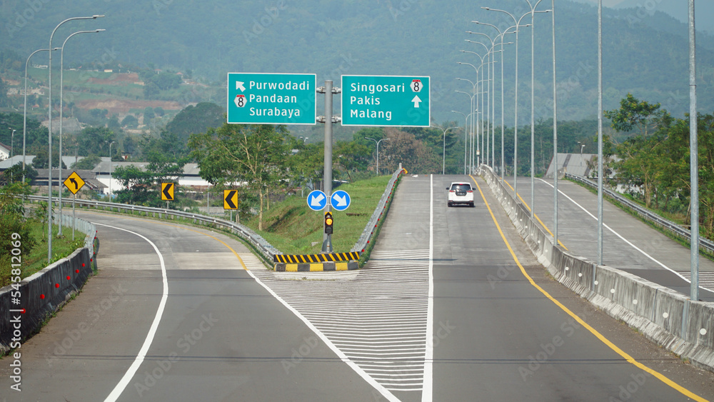 Trans Java toll road at noon. There are signs for the city of Surabaya ...
