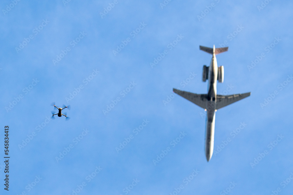 The drone is flying on low height under airplane with flying above the ...