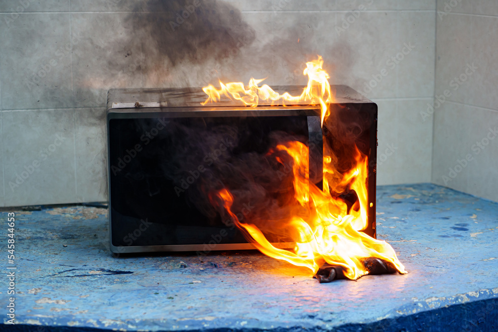 microwave oven on fire. the concept of fire in the kitchen and malfunctions, breakdowns of ...