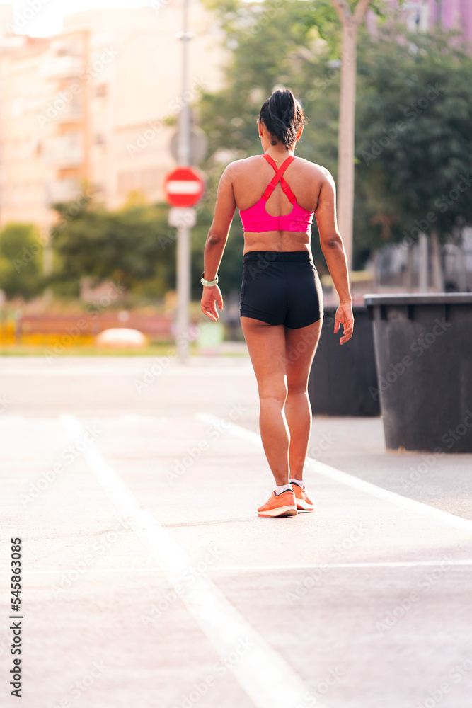 rear view of an unrecognizable sportswoman walking on the city's ...