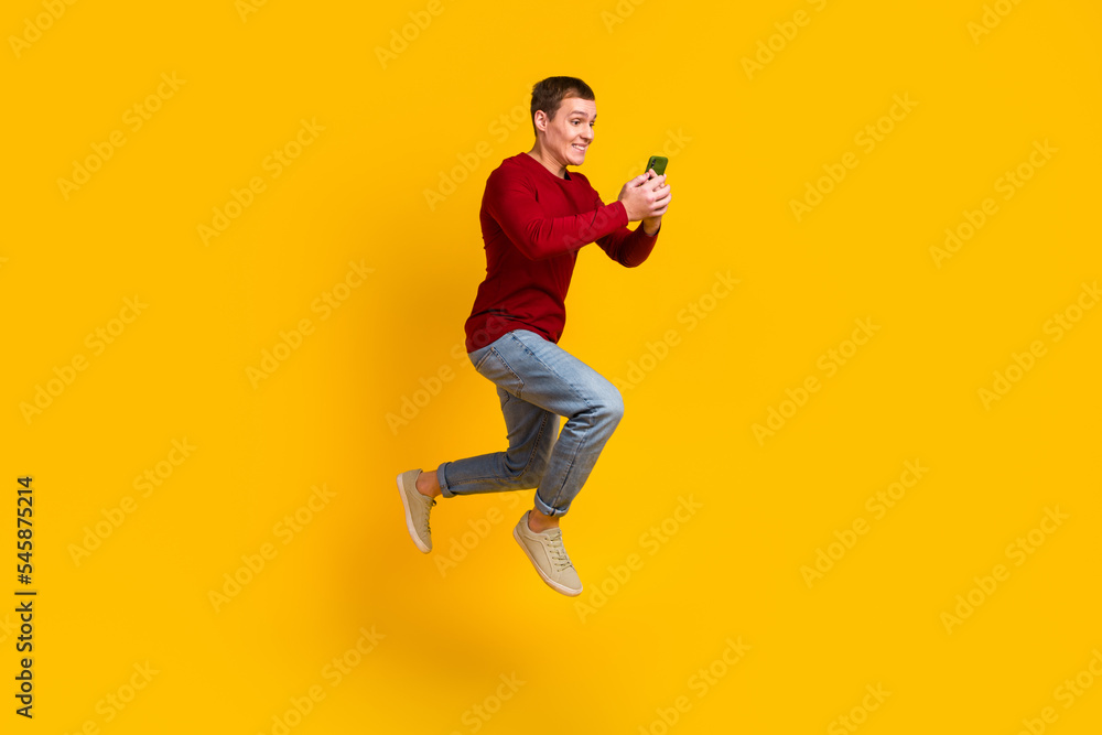 Full body photo of handsome guy jumping high holding telephone rushing ...