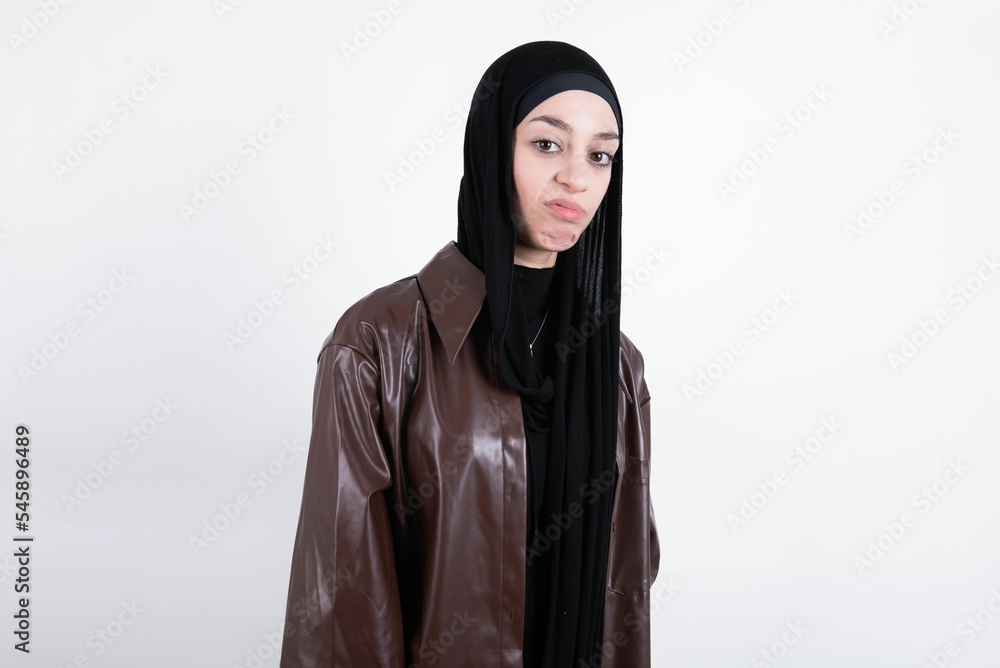 young beautiful muslim woman wearing hijab and leather jacket over ...