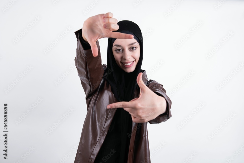 Positive young beautiful muslim woman wearing hijab and leather jacket ...