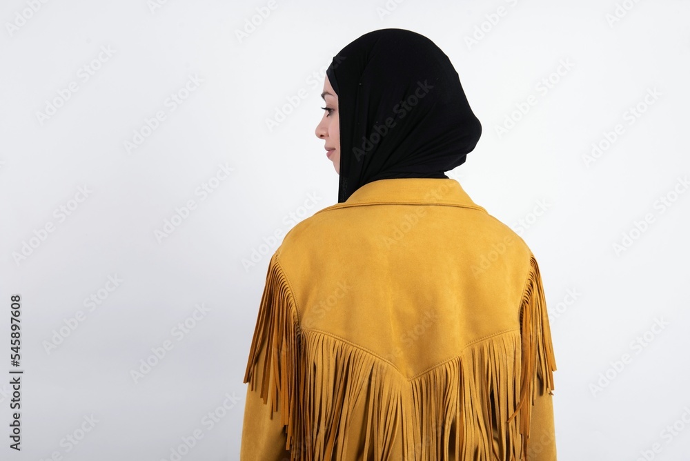 The back view of young beautiful muslim woman wearing hijab and yellow ...