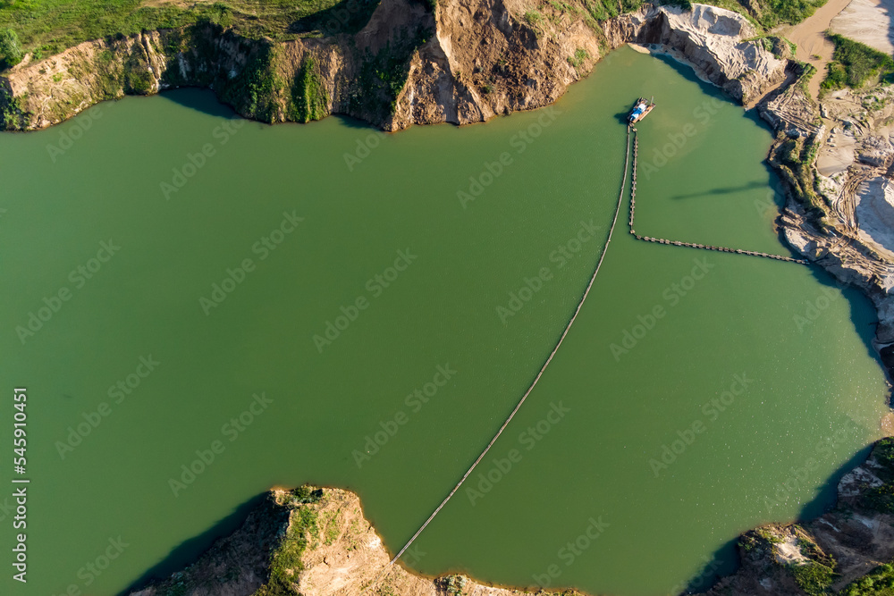 Sand mining in a flooded sand pit with a floating dredger, aerial view ...