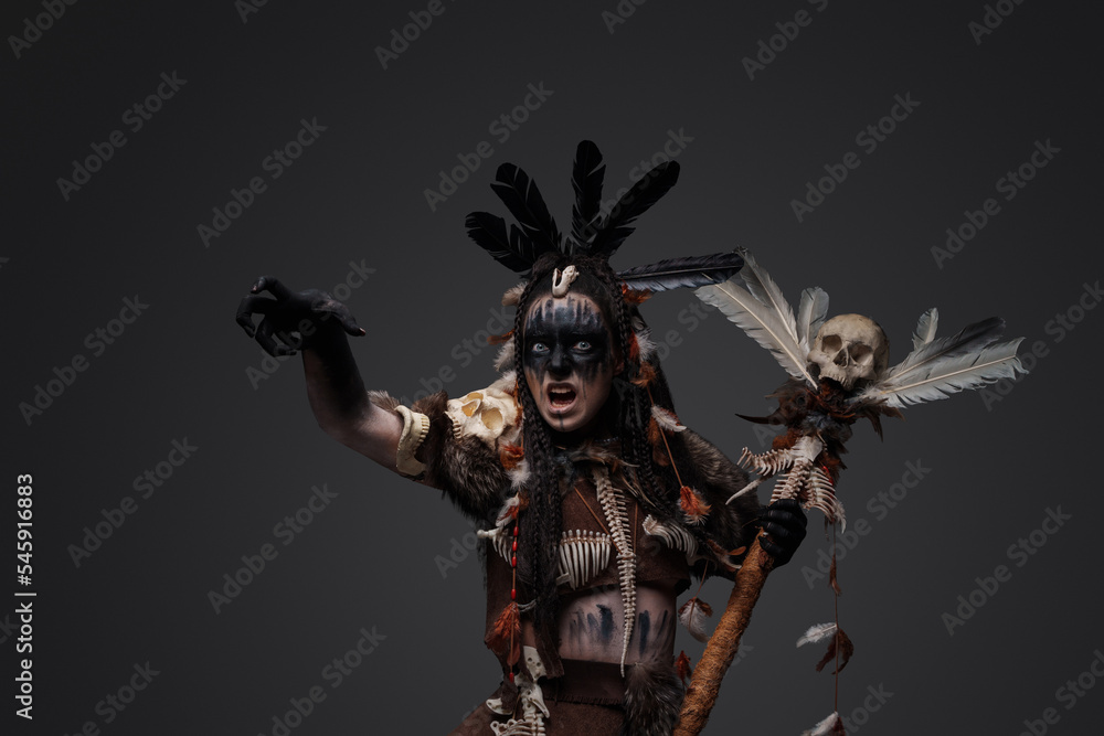 Shot of screaming dark wizard dressed in aboriginal attire against grey ...