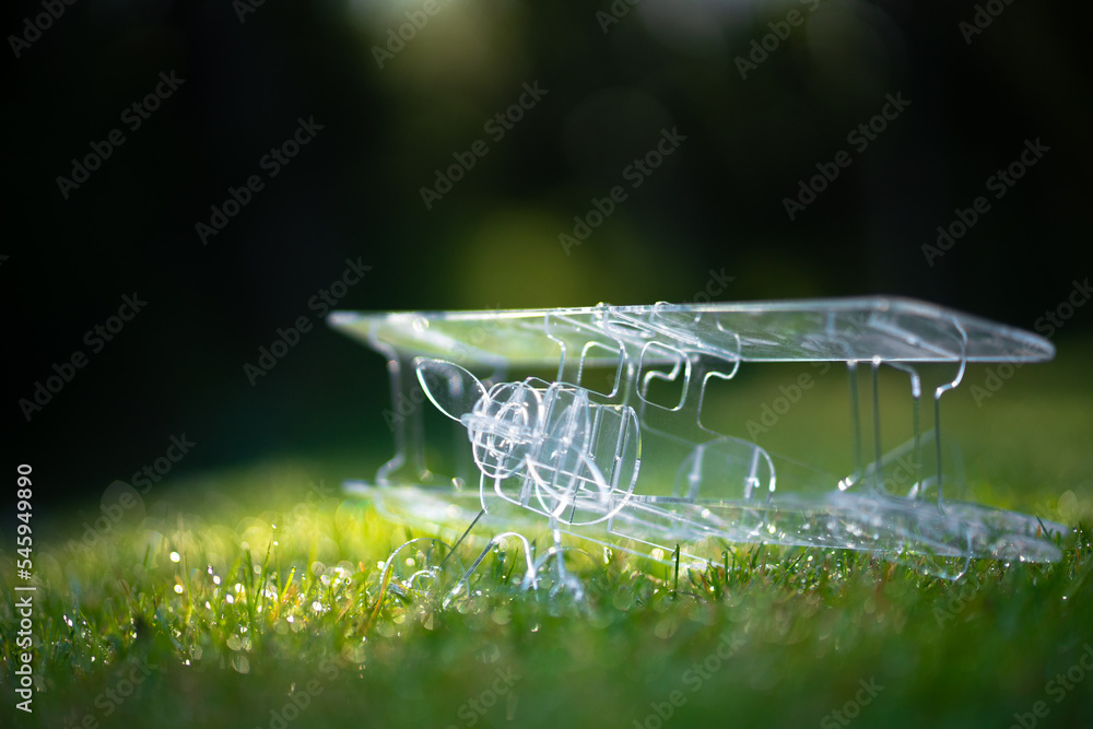 Transparent plane made of ABS plastic on green grass.Laser cutting ...