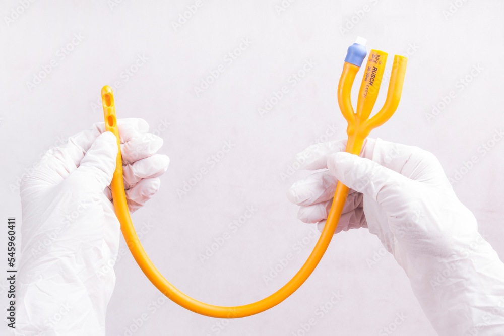 pringsewu, Lampung; November 12, 2022; doctor's hand holding orange rush 3-way catheter tube ...