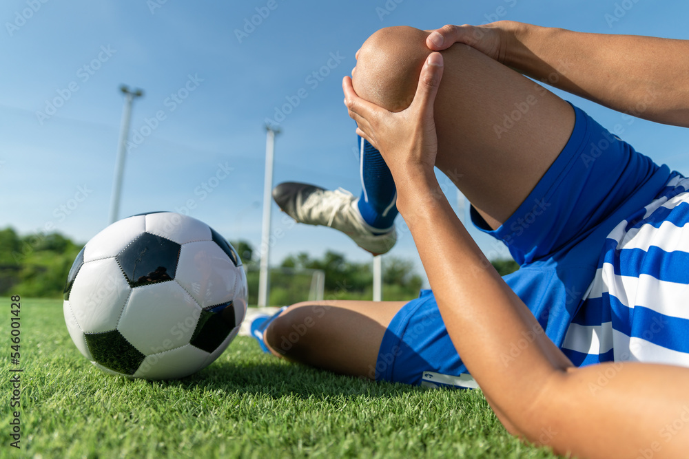 Athlete standing with ball on football field during sunrise, soccer ...