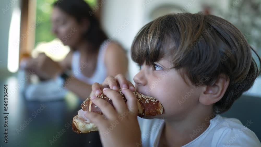 Little boy eating sandwich. Child taking a bite of bread. Kid eats ...