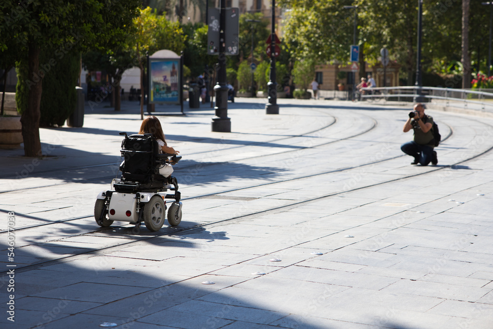young disabled woman in a wheelchair with reduced mobility is posing ...