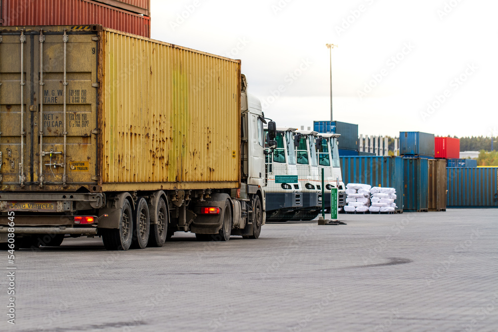 Truck while loading in logistic shipping yard with cargo container ...