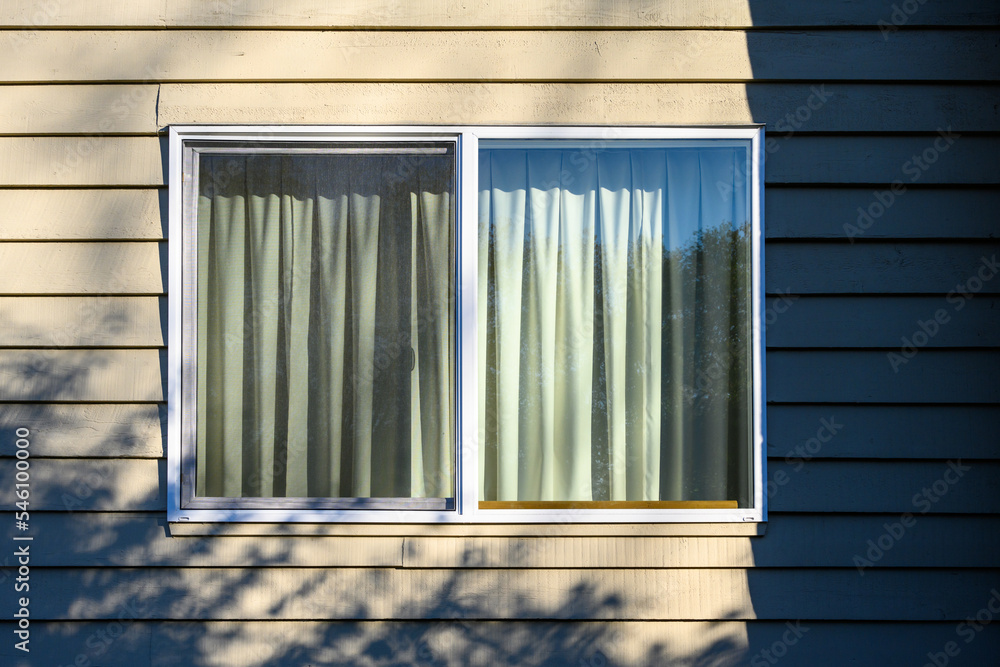 Exterior view of large window with closed curtains, residential ...