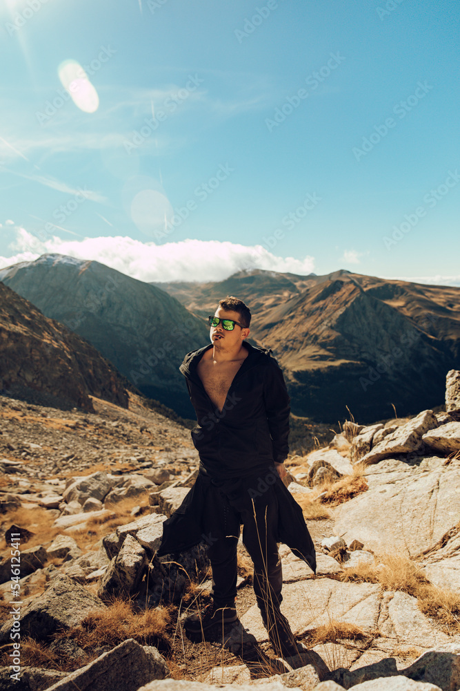 Boy taking off his jacket while climbing a mountain path Stock Photo ...