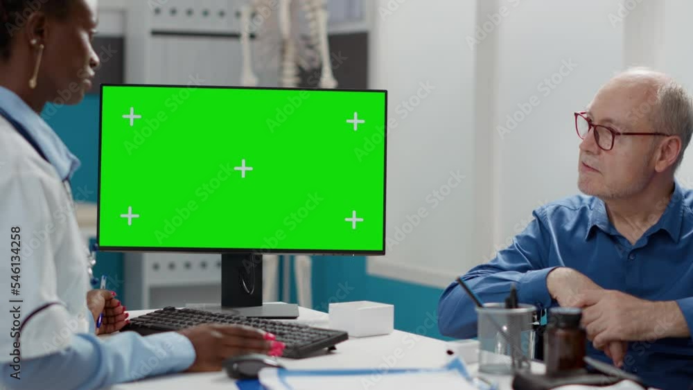 Physician and elderly man in wheelchair analyzing greenscreen in ...