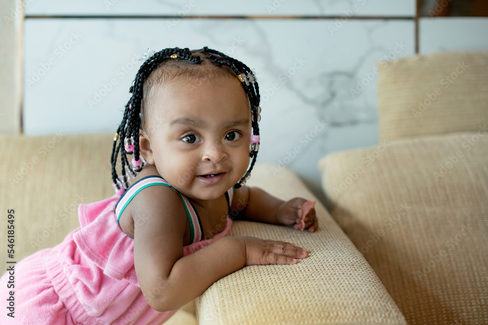 Cute African baby girl enjoying her braids, looking at camera, African ...