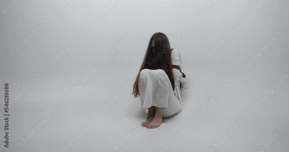 Cinematic footage of girl with face covered with long red hair, dressed ...