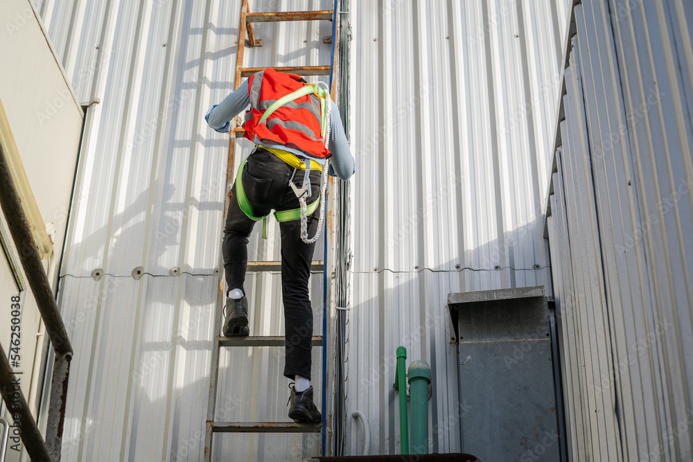 Construction worker wearing safety harness belt during working on roof ...
