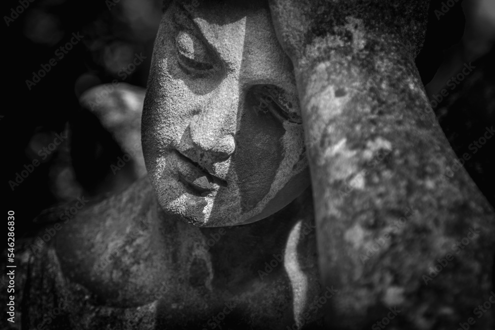 Close up very ancient stone statue of man crying on the tomb for the ...