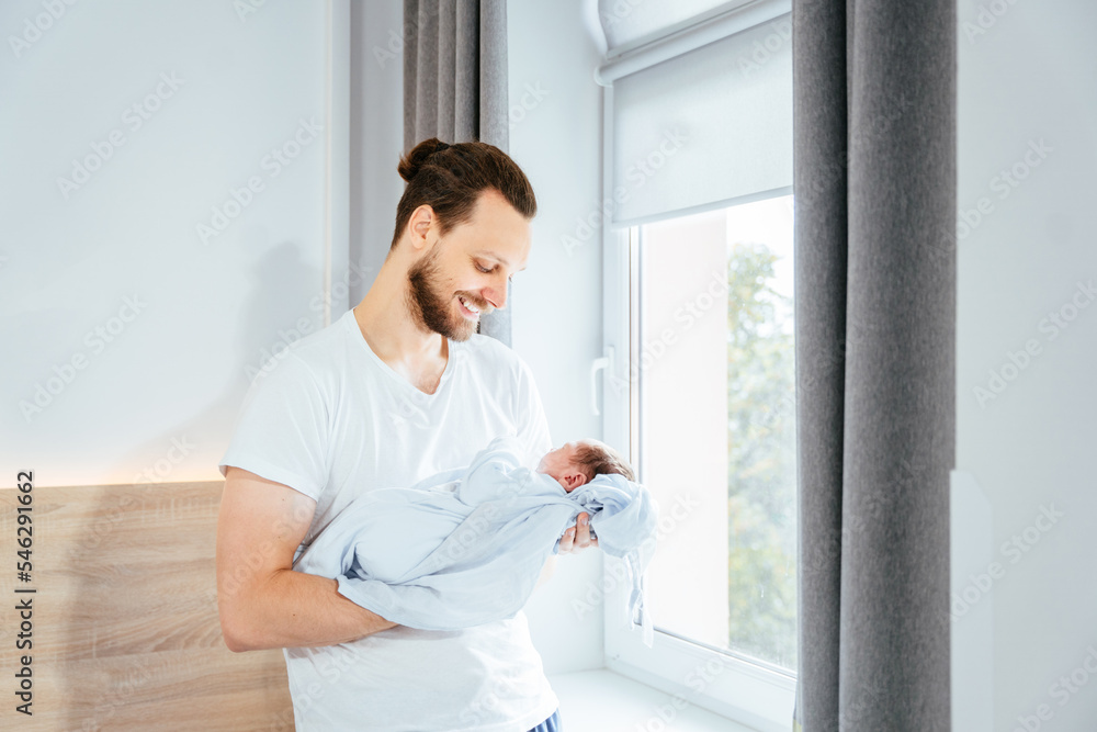 Happy father holding his lovely cute newborn baby boy in hospital room ...