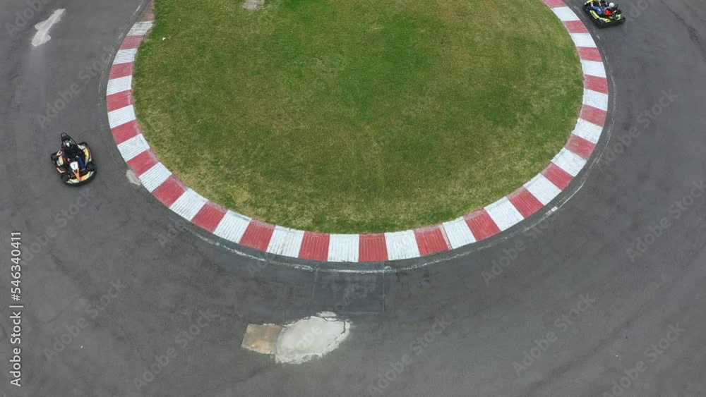 Aerial top view of the go-kart track from the drone. Kart racers drive ...