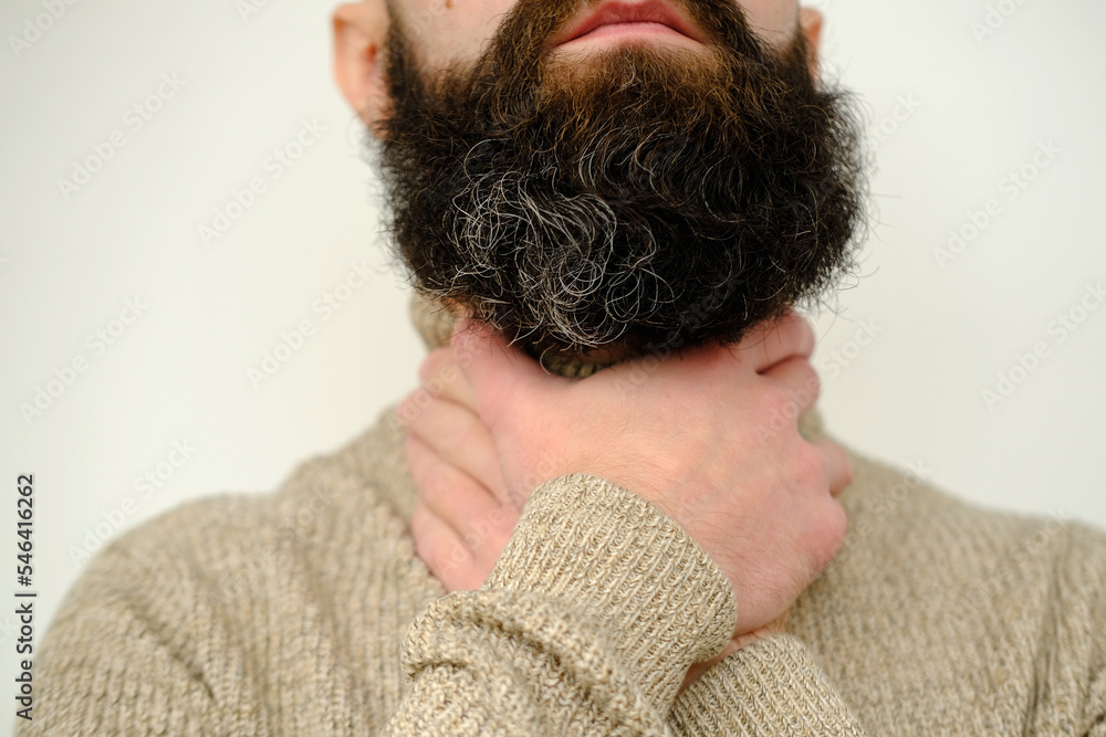 close-up of male hands on neck, young man holds throat, guy with beard ...