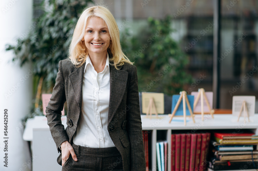 Confident middle aged business woman in stylish suit posing at the ...