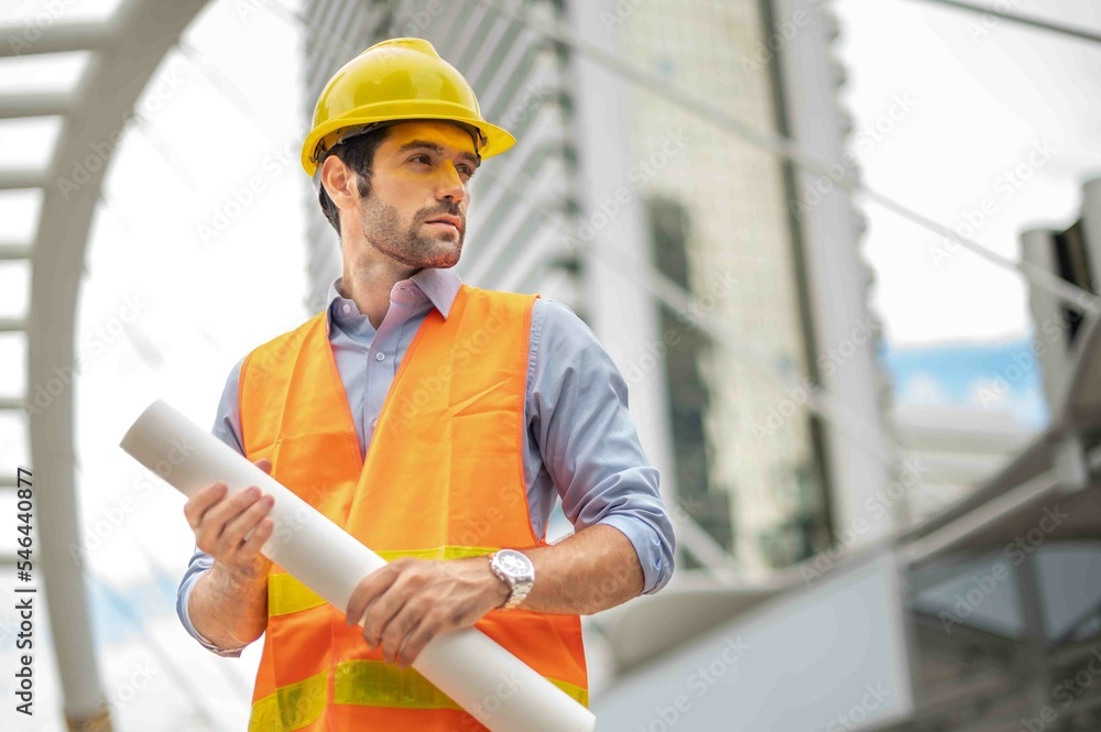 Caucasian man engineers use a smartphone for talking, wearing an orange ...
