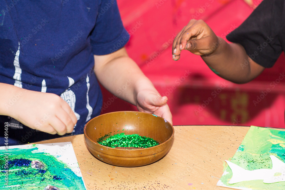 Two kids works together in a preschool class. Kids hands are during ...