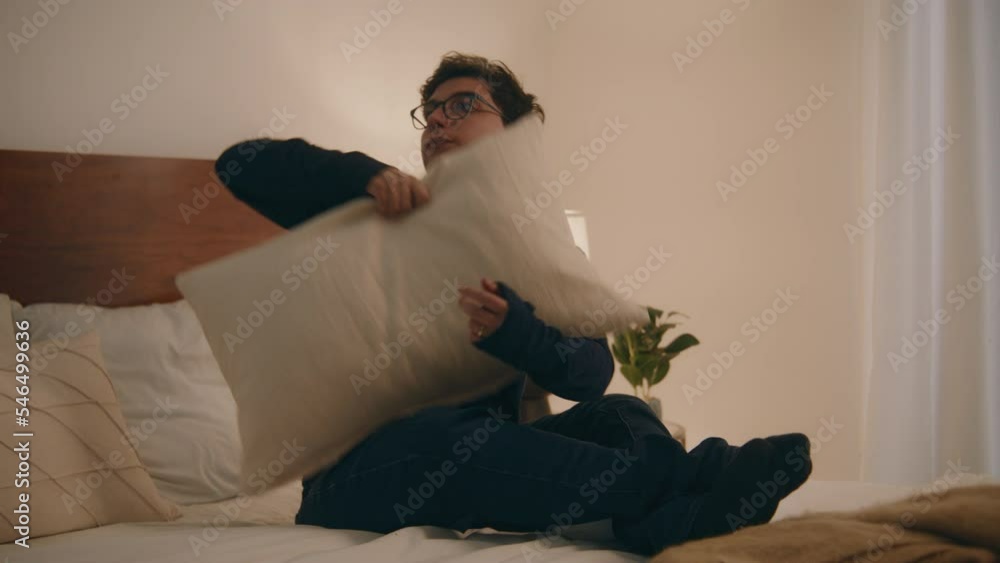 man sits up and grabs pillow in bed Stock Video | Adobe Stock