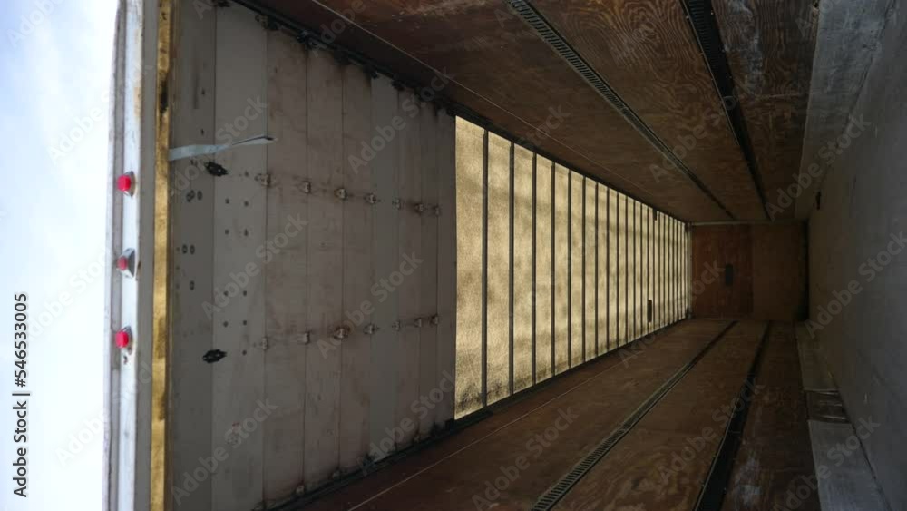 Tilt down view inside an empty white semi-truck cargo trailer, vertical ...