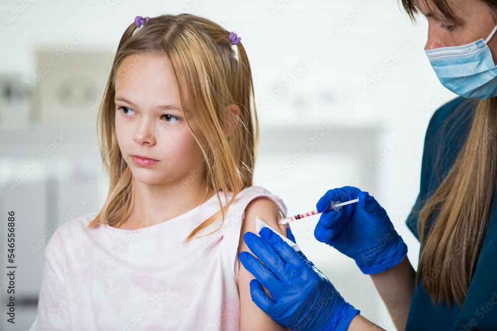 Female nurse with surgical mask and in gloves giving vaccine injection ...