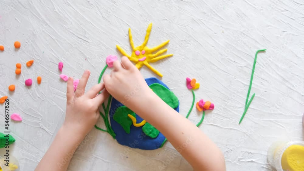 Child sculpturing plasticine planet for earth day. Protection of ...