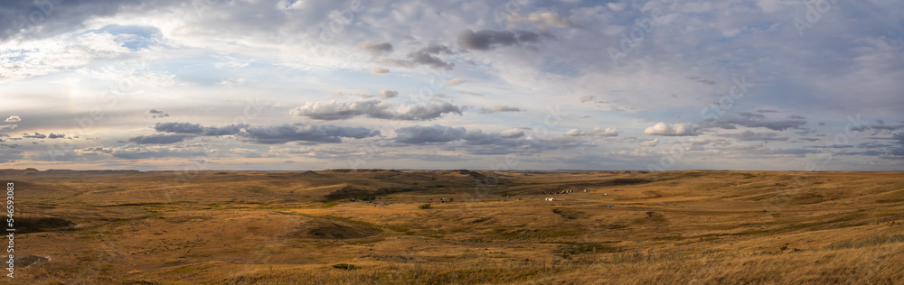 A distant campground in a dry treeless prairie setting under a sky with ...