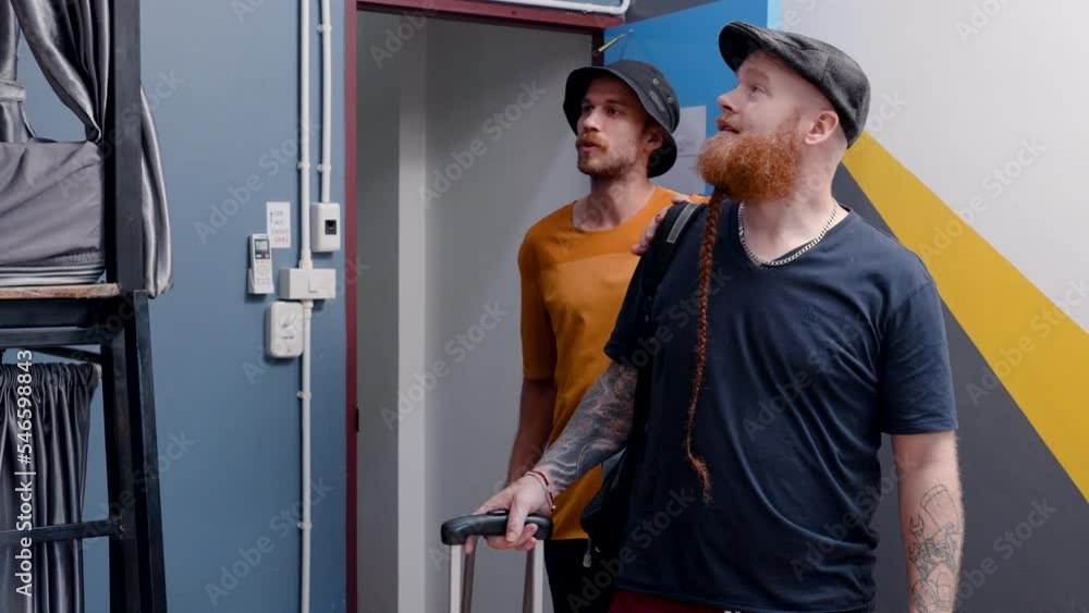 Vidéo Stock 4K, Two male best friends are opening the door to check ...