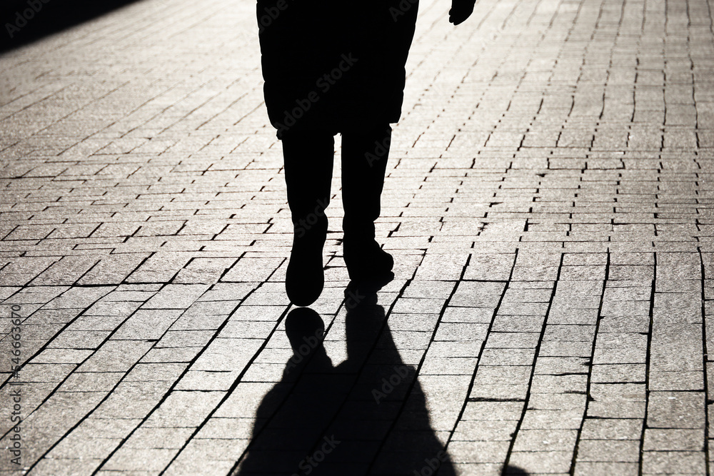 Black silhouette and shadow of lonely woman walking on a street. Female ...