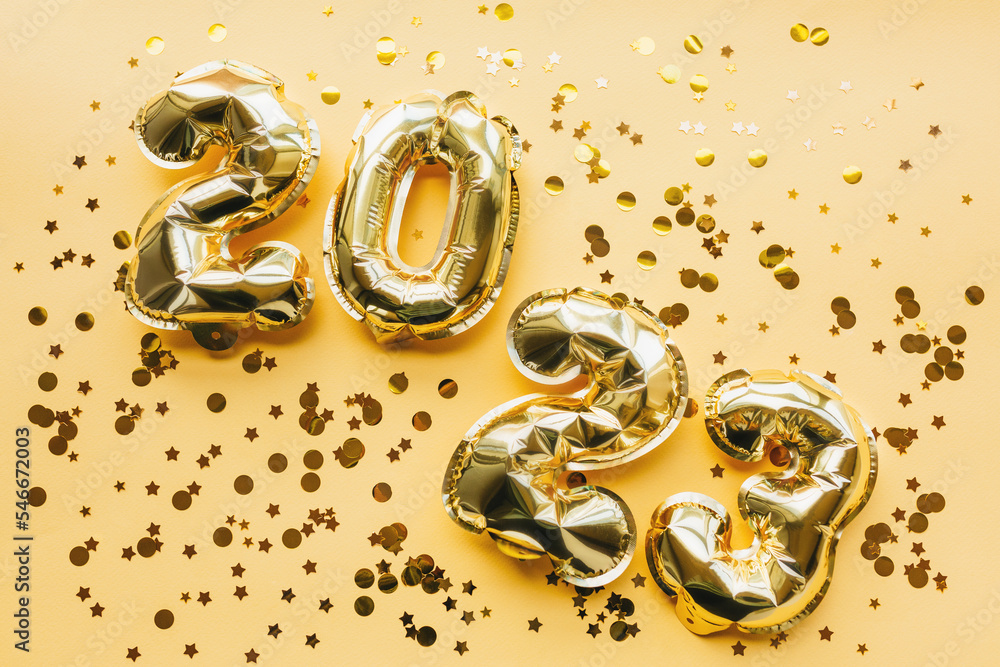 Scattered balloons made of gold foil in the form of the numbers 2023 on ...