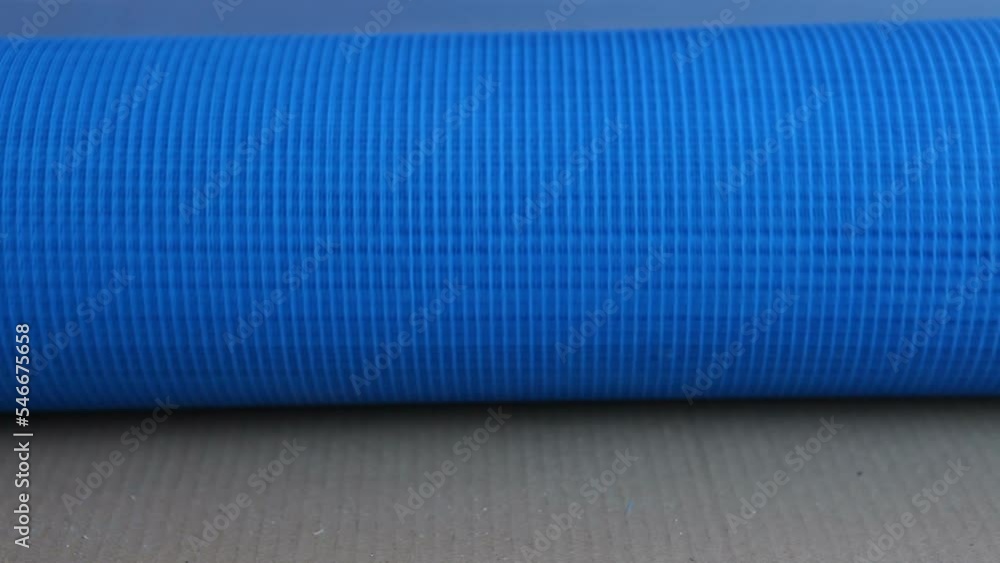 Blue plastic reinforcing mesh in a roll for wall plastering. Front grid ...