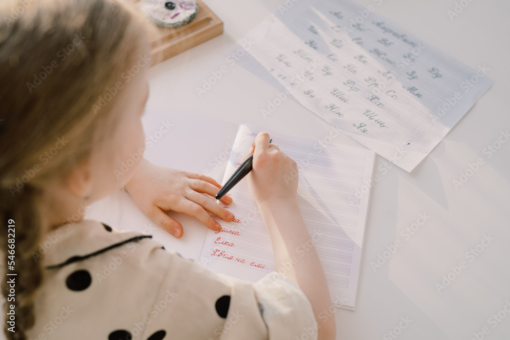 Little girl practicing writing alphabet Stock Photo | Adobe Stock