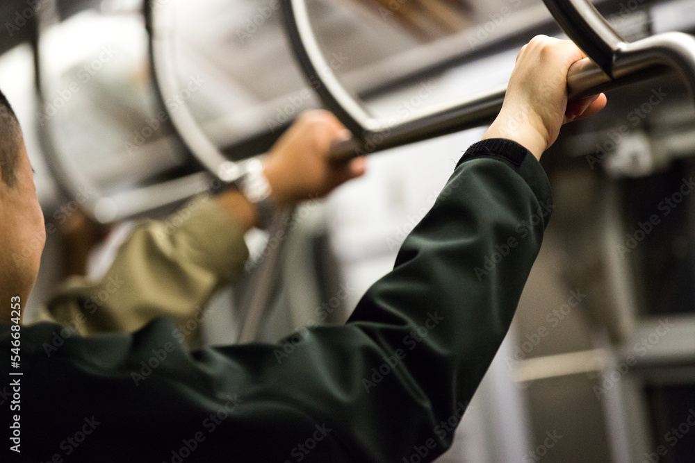 Crop people holding train handrail while riding Stock Photo | Adobe Stock