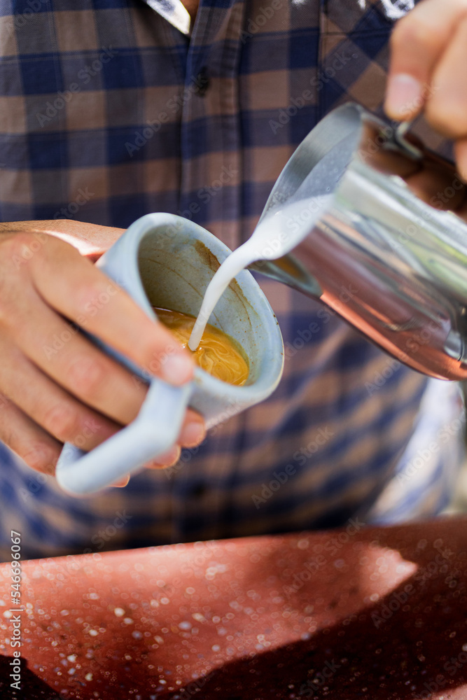 Barista pouring milk to prepare latte Stock Photo | Adobe Stock