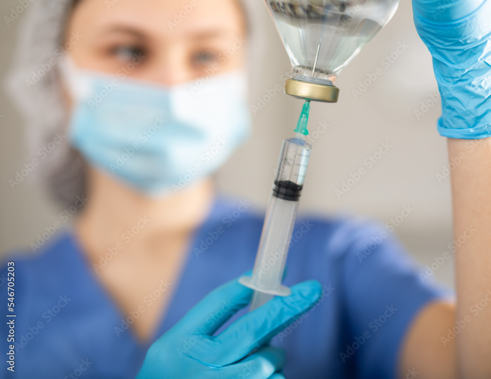 Focused young female nurse in the treatment room at the clinic prepares ...
