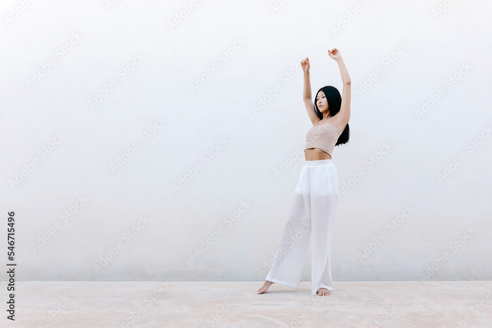 Asian dancer making step with raised arms Stock Photo | Adobe Stock