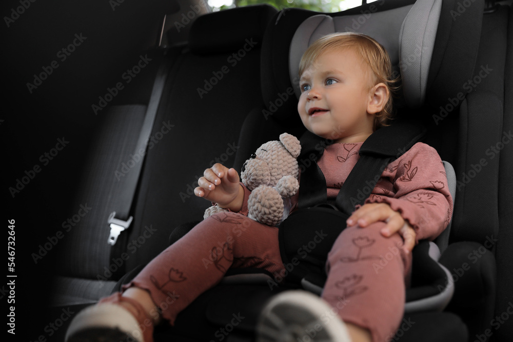 Cute little girl sitting in child safety seat inside car Stock Photo ...
