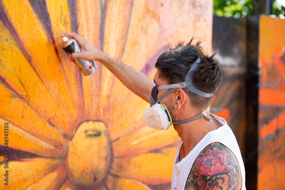 Graffiti artist painting large floral mural Stock Photo | Adobe Stock