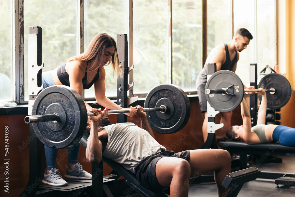 People training bench press in the gym with spotters Stock Photo ...
