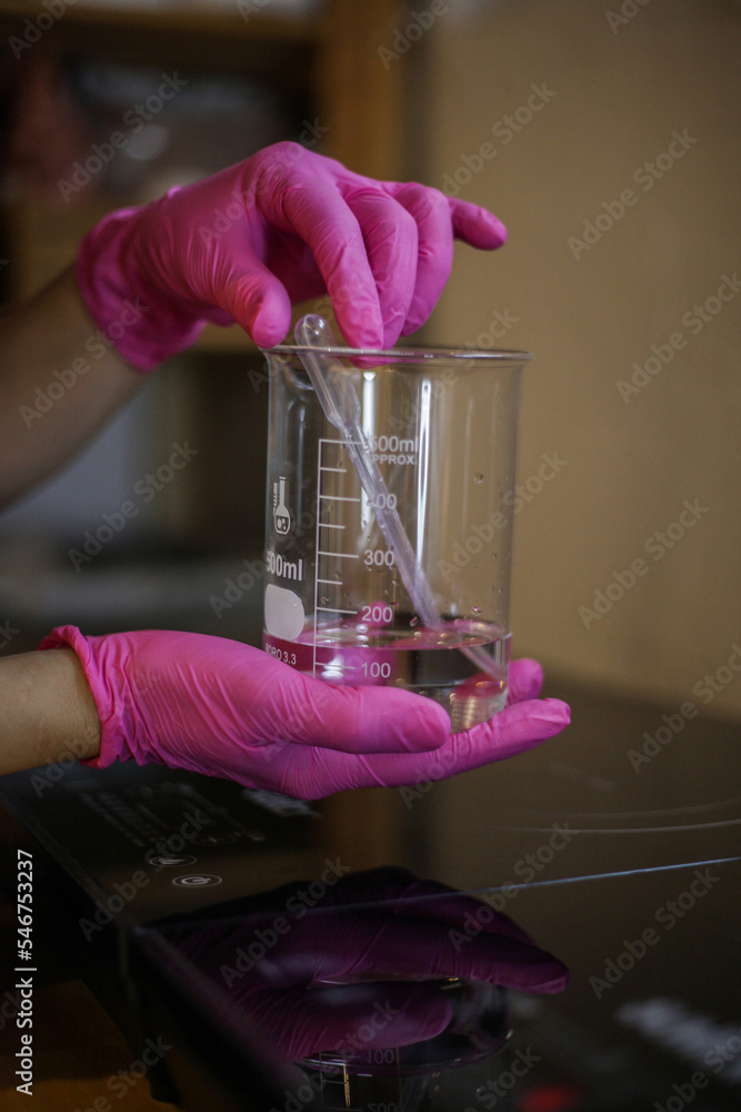 Anonymous Scientist Measuring Liquid in Beaker Stock Photo | Adobe Stock